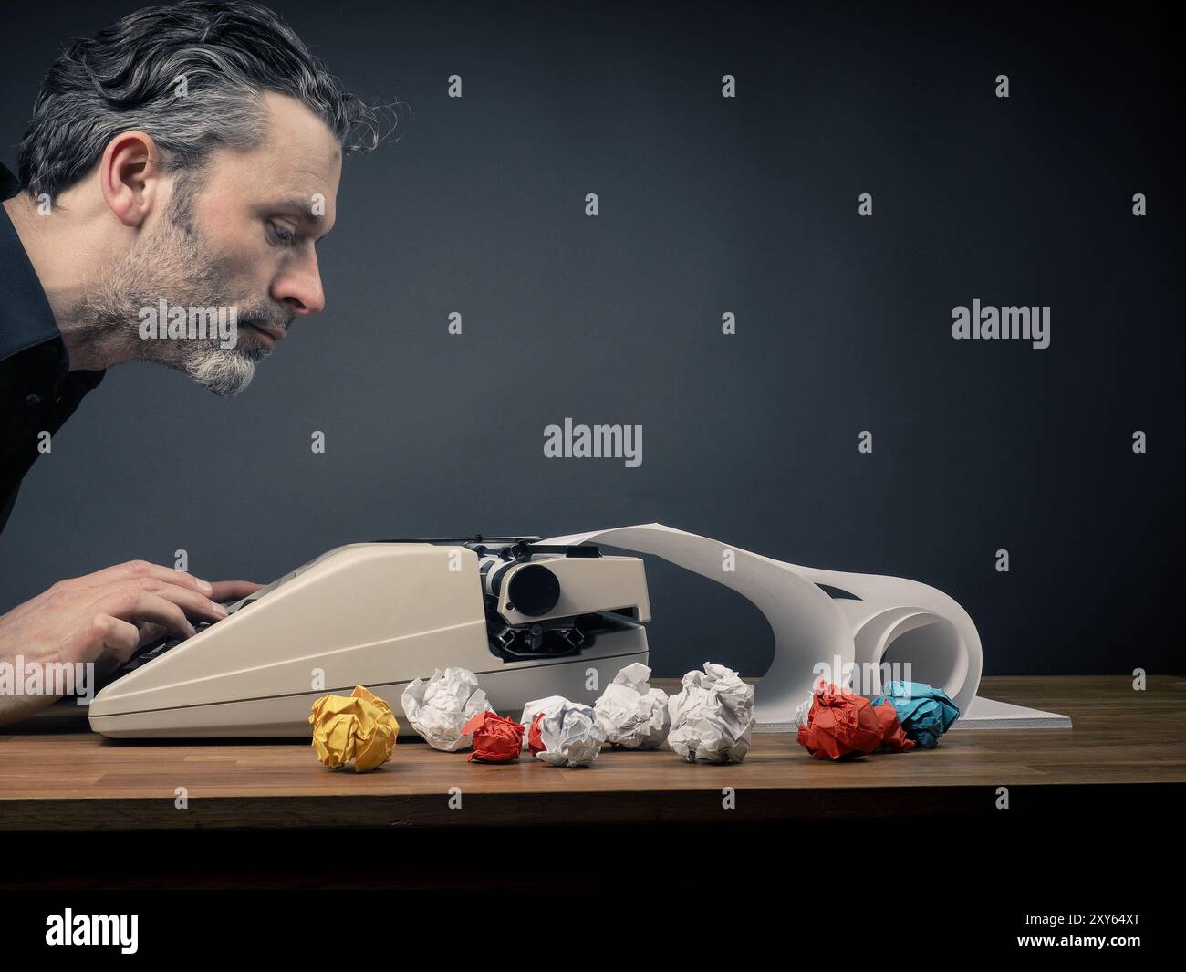 Editor with his typewriter and many crumpled paper, creativity concept ...