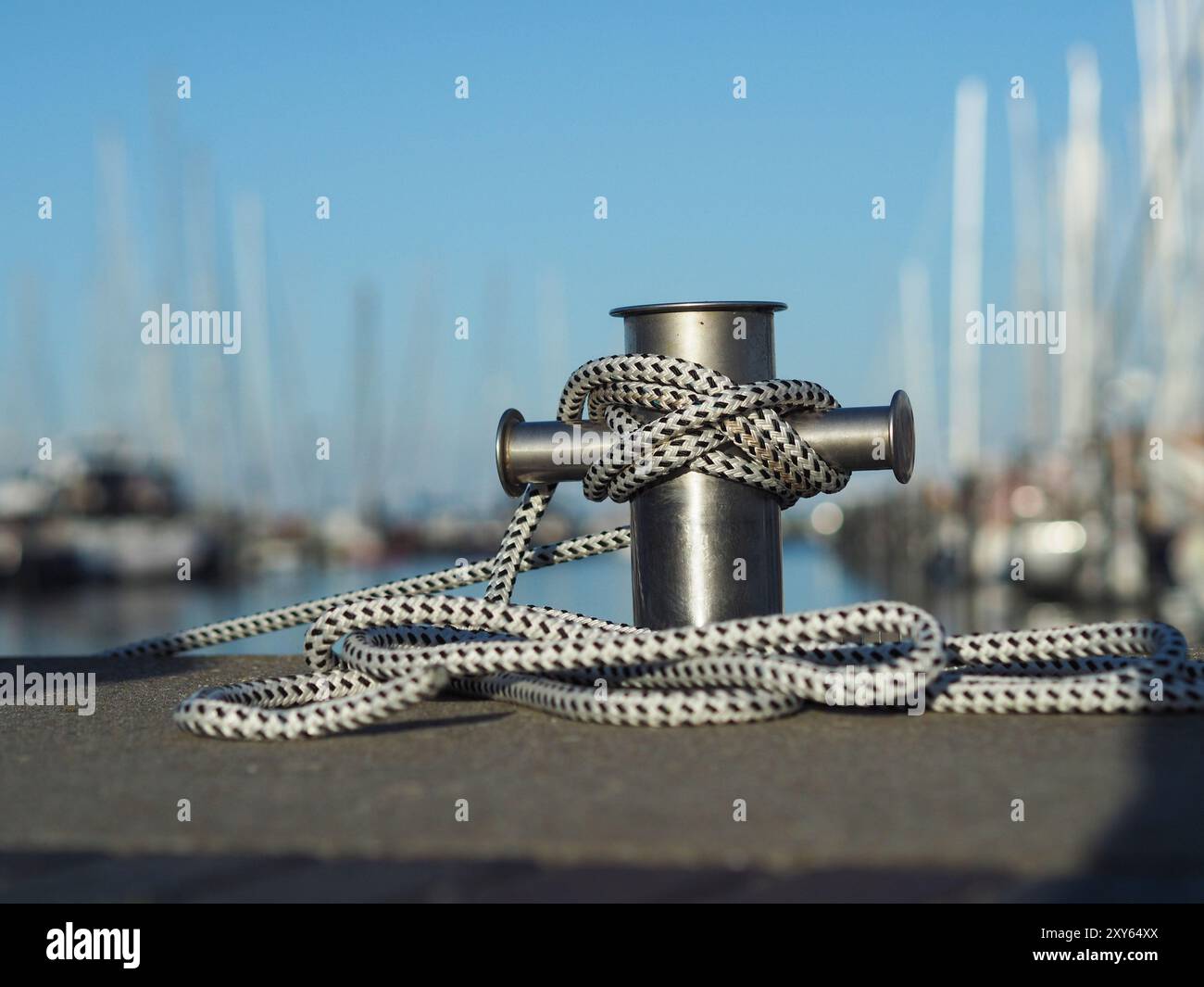 Stainless steel bollard with rope in a luxury marina, soft bokeh with ...