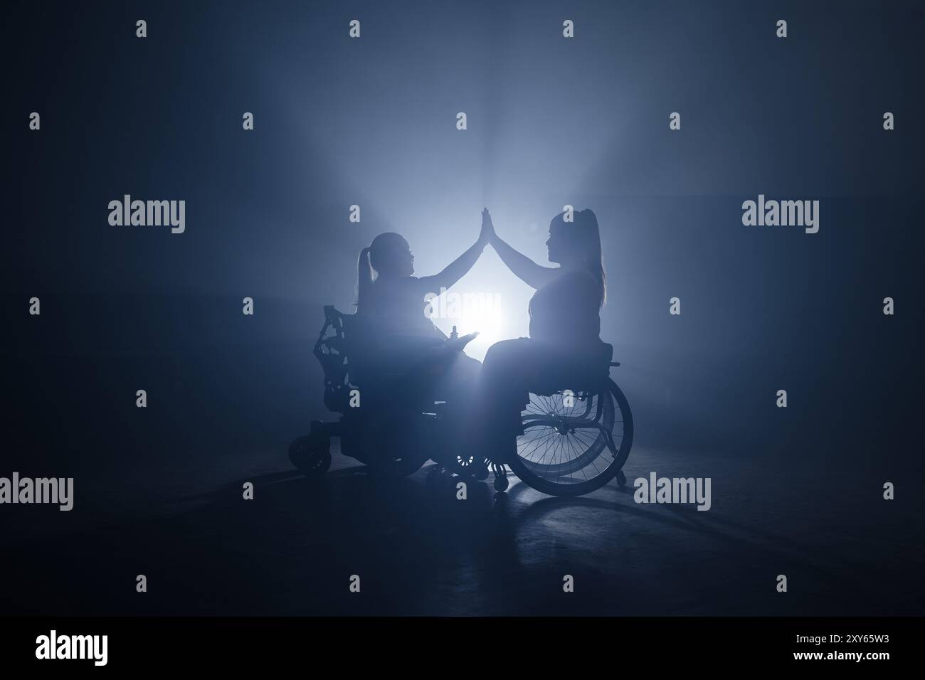 Two happy female para wheelchair dancers giving high five in a dance ...