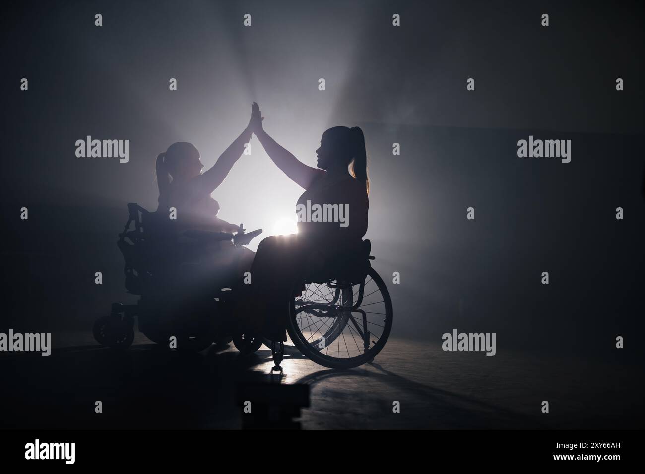 Two happy female para wheelchair dancers giving high five in a dance ...