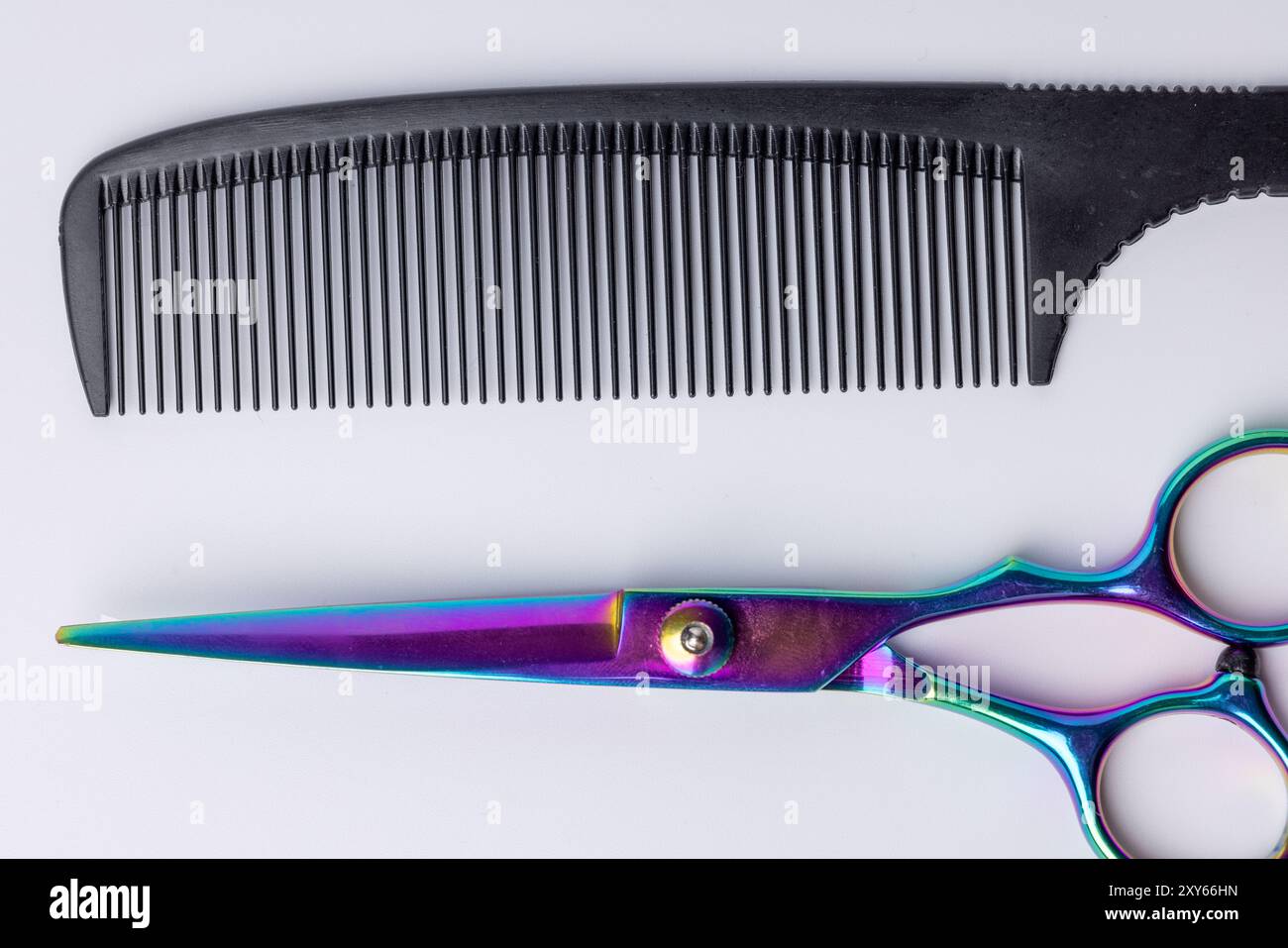 A detailed top-down view of a black barber's comb and scissors centered ...