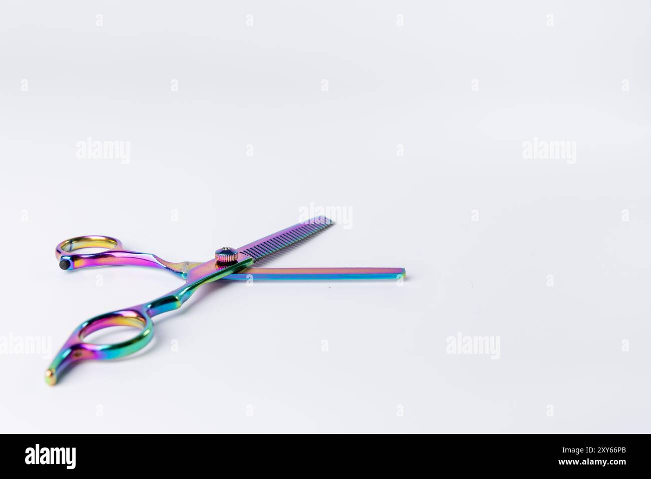 A sleek, open scissor rests on the left side of a white background. The ...