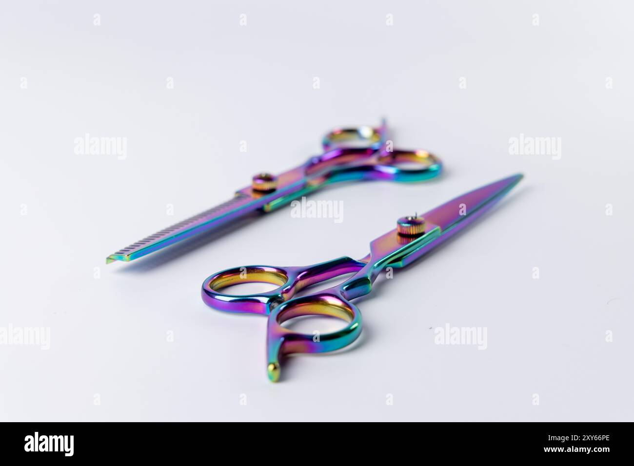 Two pairs of scissors are centrally positioned on a clean white ...