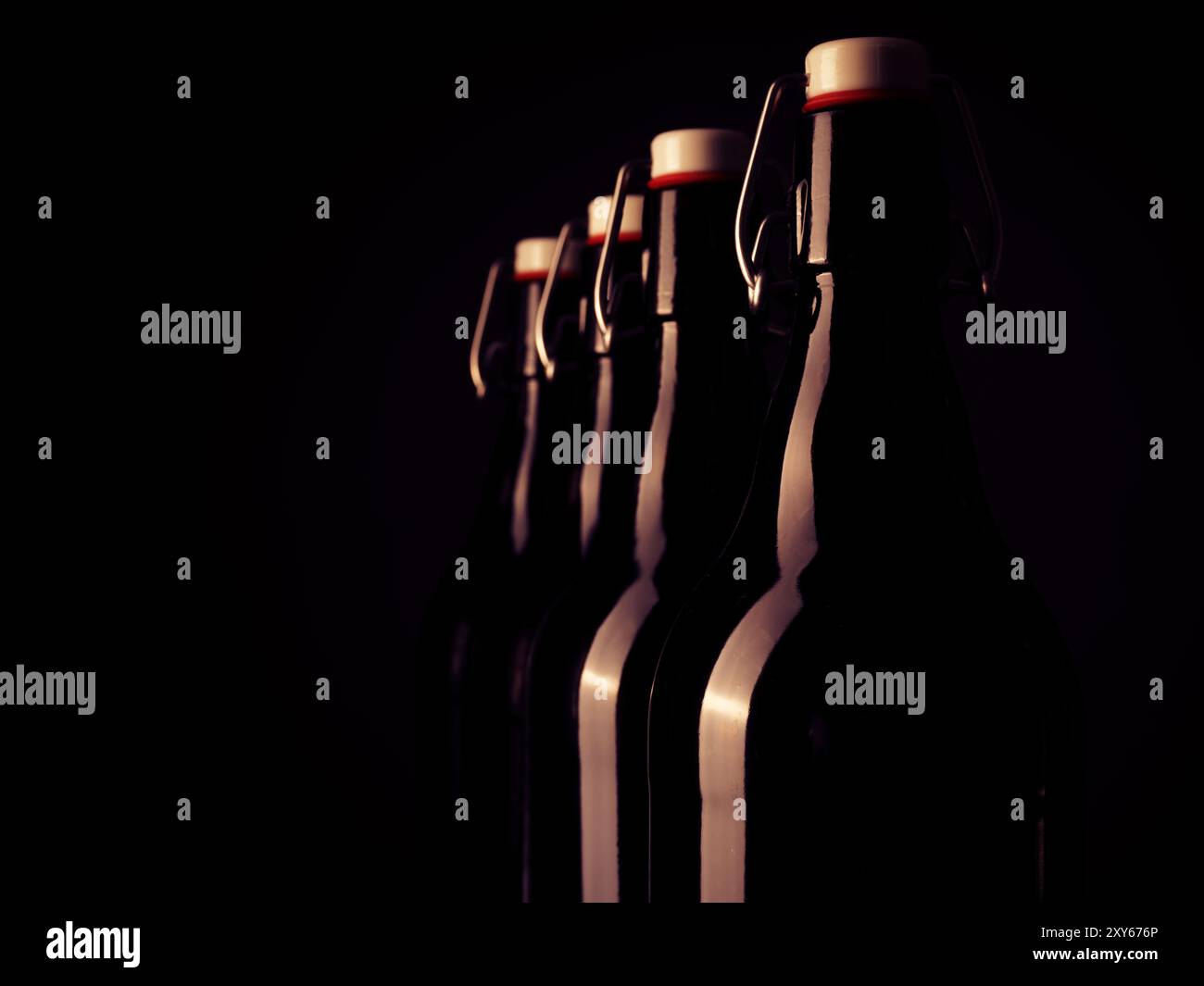 Four bottles of beer in a row on a dark background, retro color toned ...