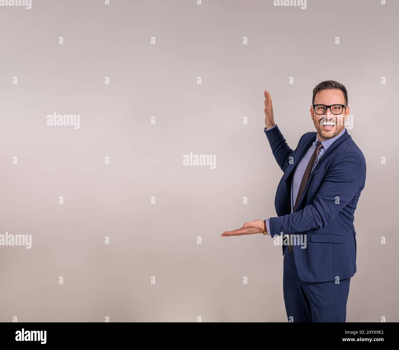 Happy young salesman laughing and presenting new product while standing ...