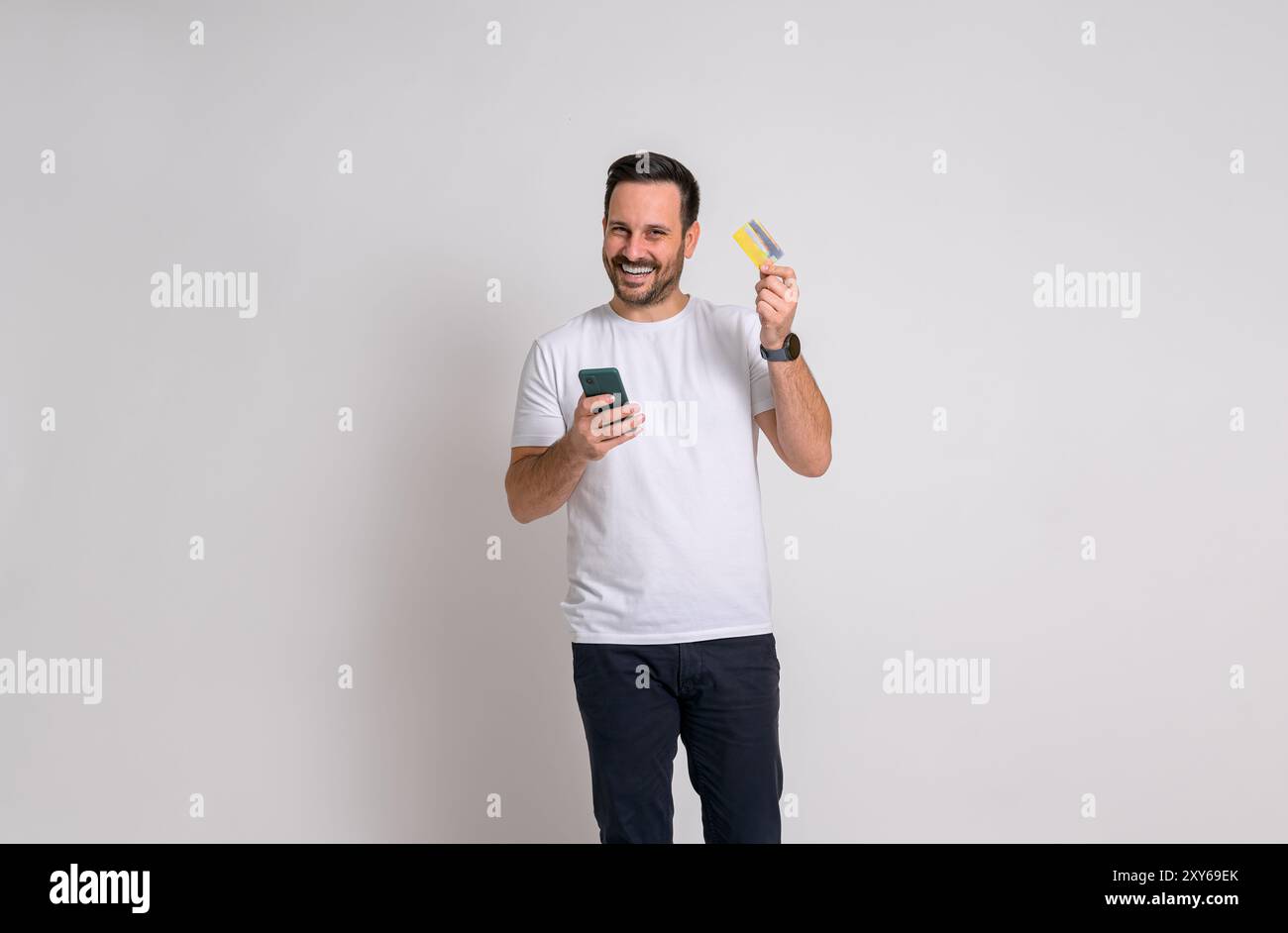 Happy male sales professional using mobile phone and showing credit ...