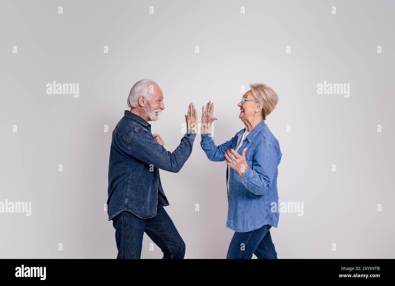 Side view of excited senior couple giving high-five and celebrating ...