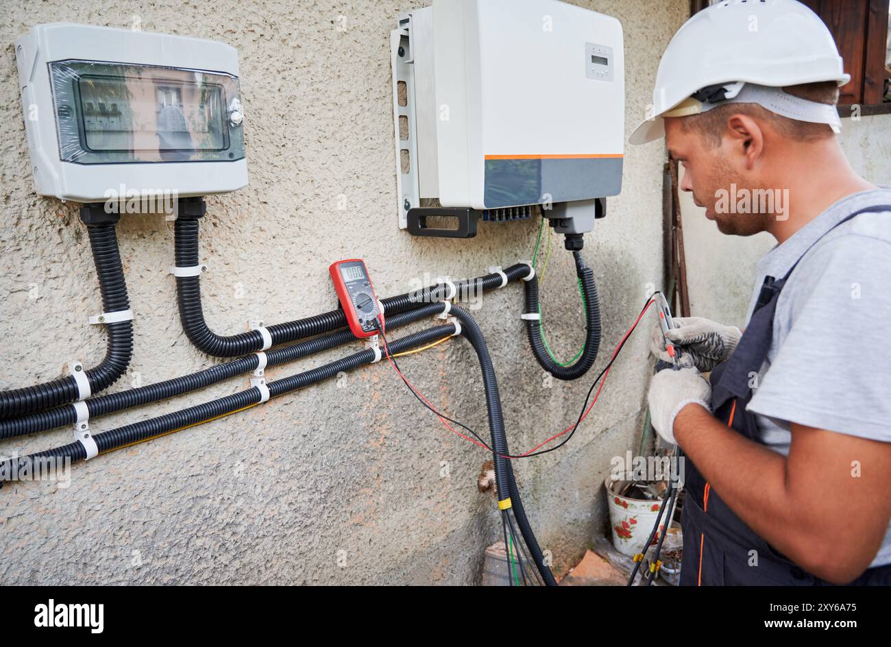 Man electrician installing solar panel system. Technician in helmet and ...