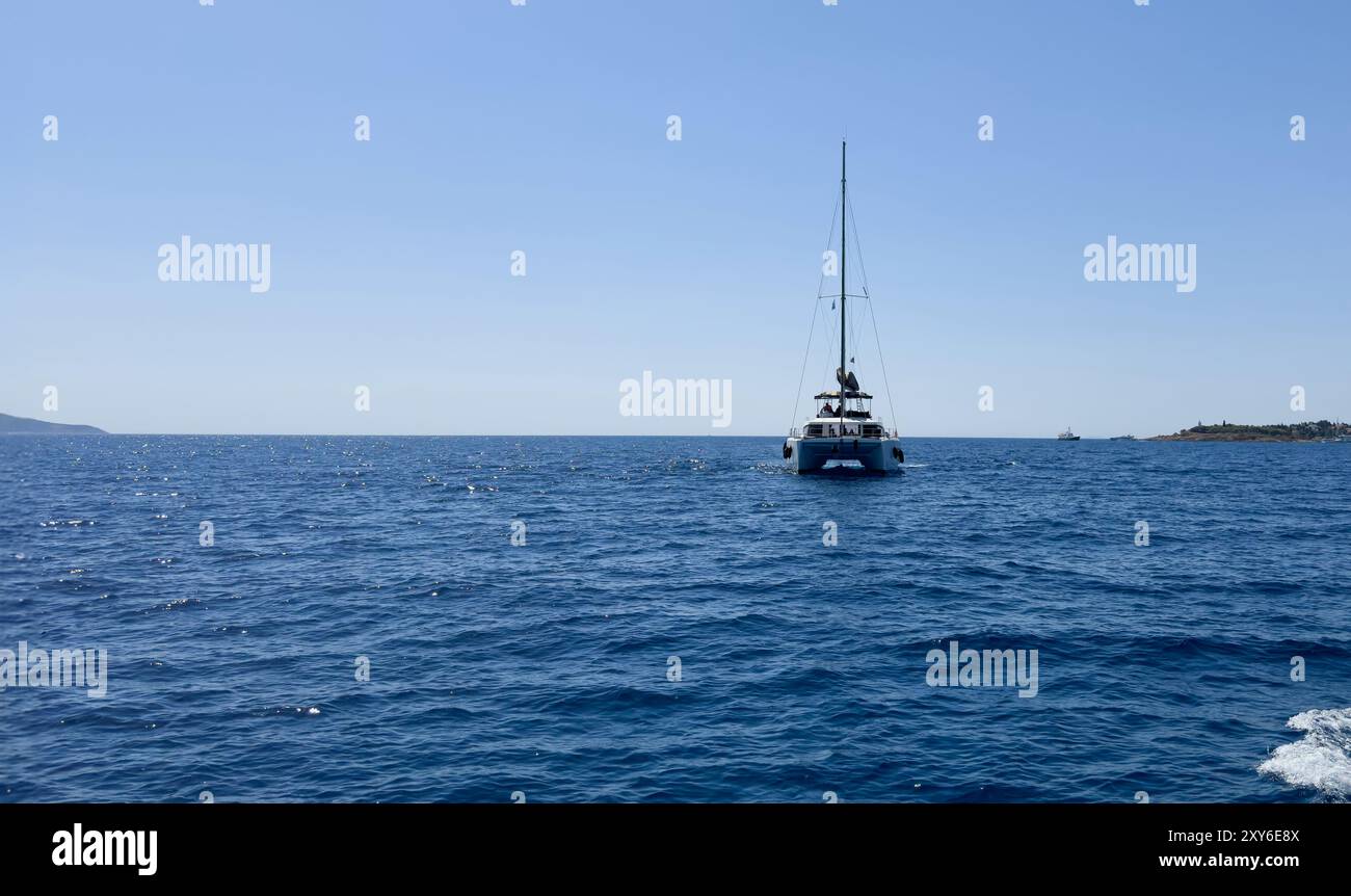 Sailing boat catamaran navigate on rippled sea, blue clear sky ...