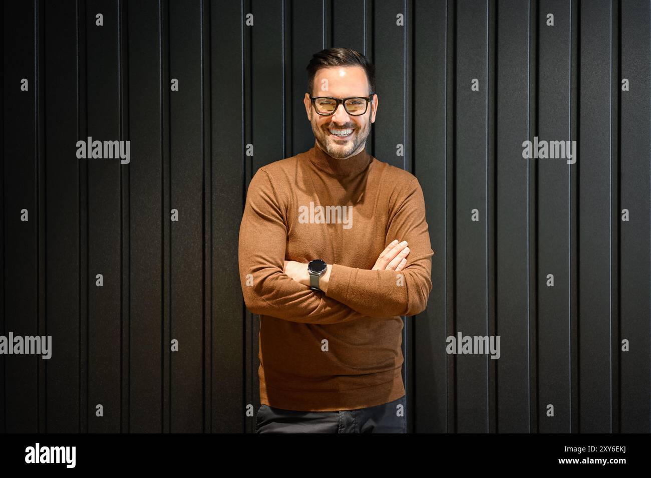 Portrait of handsome CEO with arms crossed smiling and standing ...