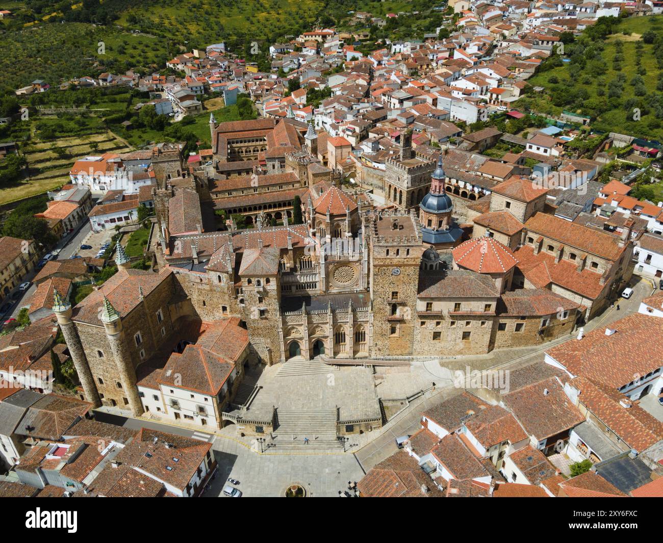 Aerial view of an old monastery with red roofs, surrounded by a village ...