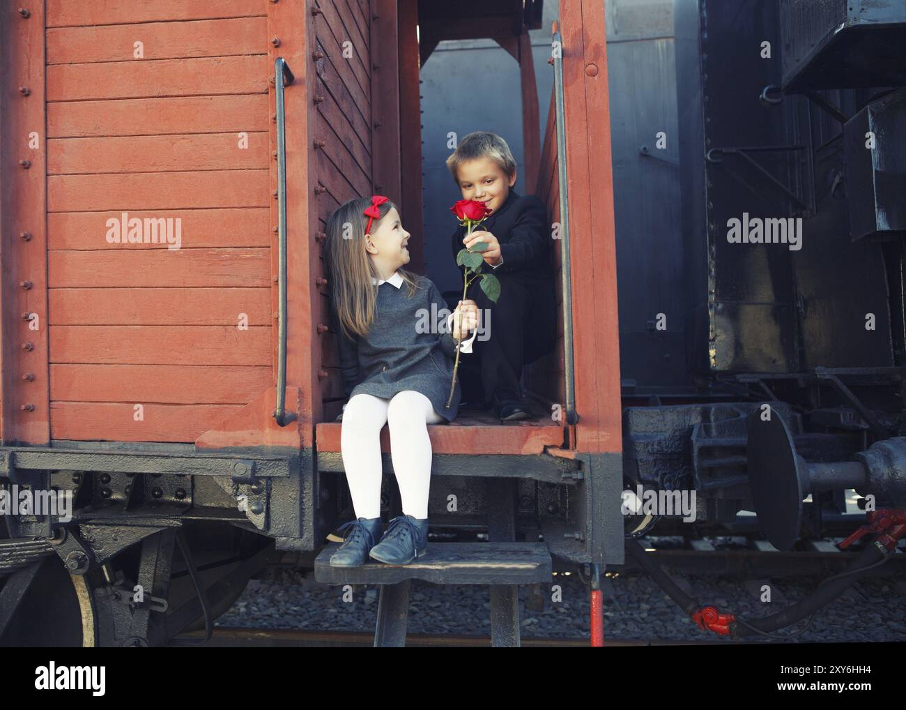 Little boy gives red rose to the little girl in the retro train Stock ...