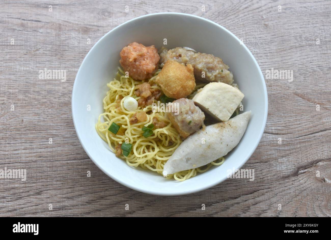 dry Chinese yellow egg noodles topping steamed Hakka meatball made from ...