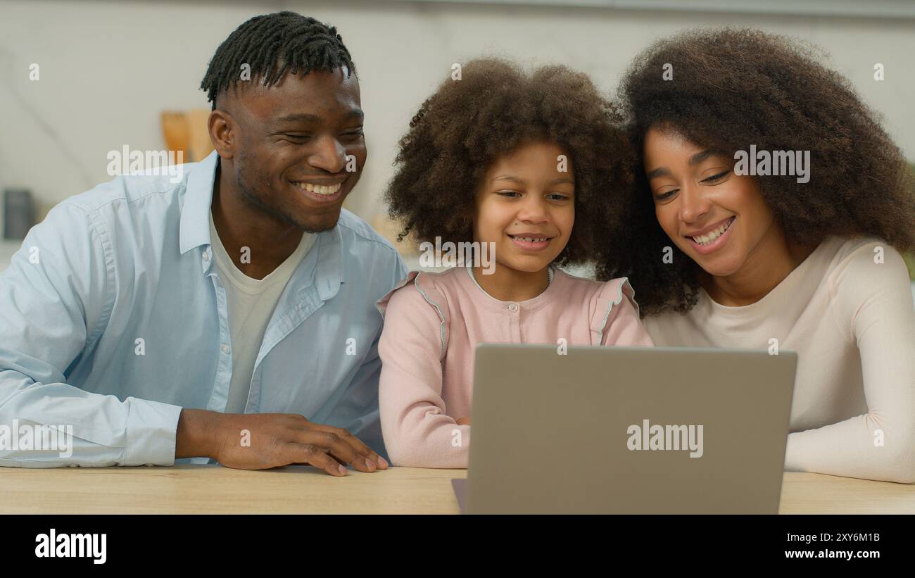 African American happy parents with little child video call with laptop family hello biracial ...