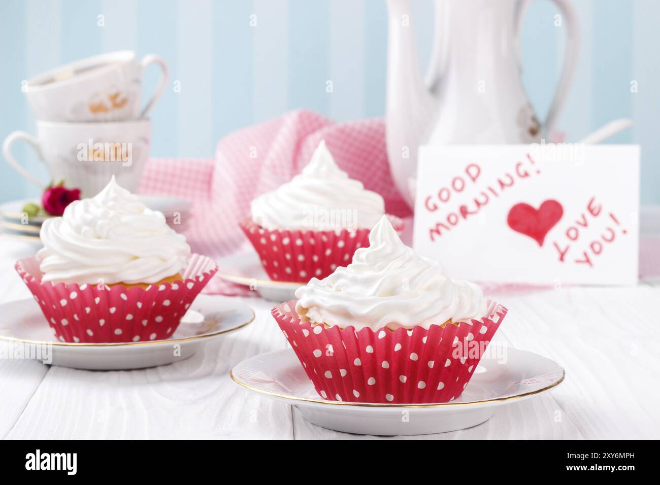 Cupcakes with white buttercream frosting on white wooden table with ...