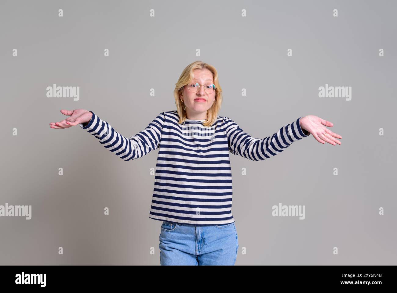 Portrait of careless businesswoman spreading hands and shrugging ...