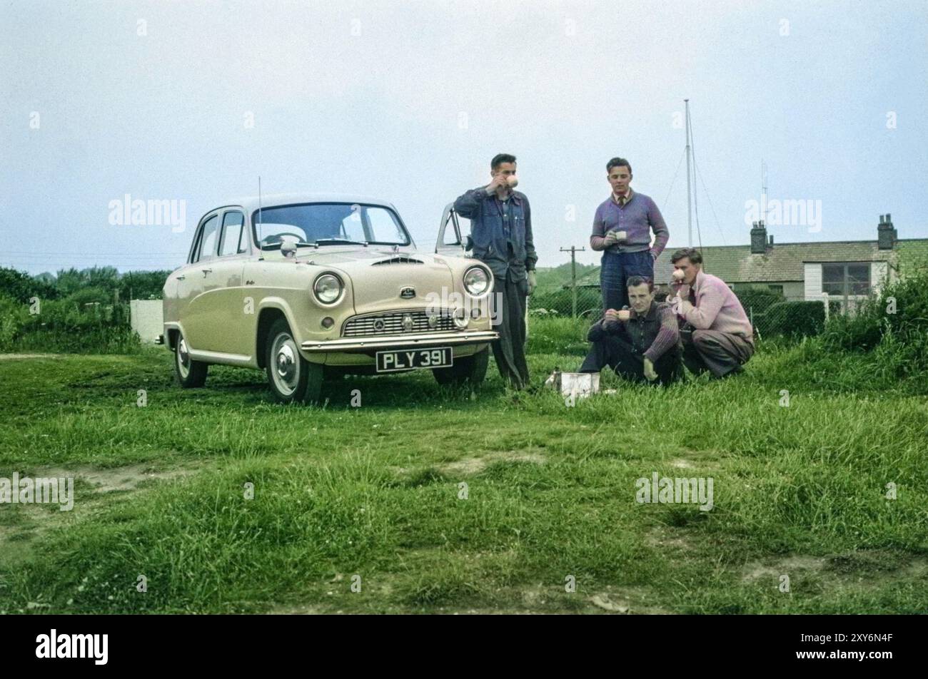 Four men with picnic teacups by Austin Cambridge A40 car starting overland drive adventure ...
