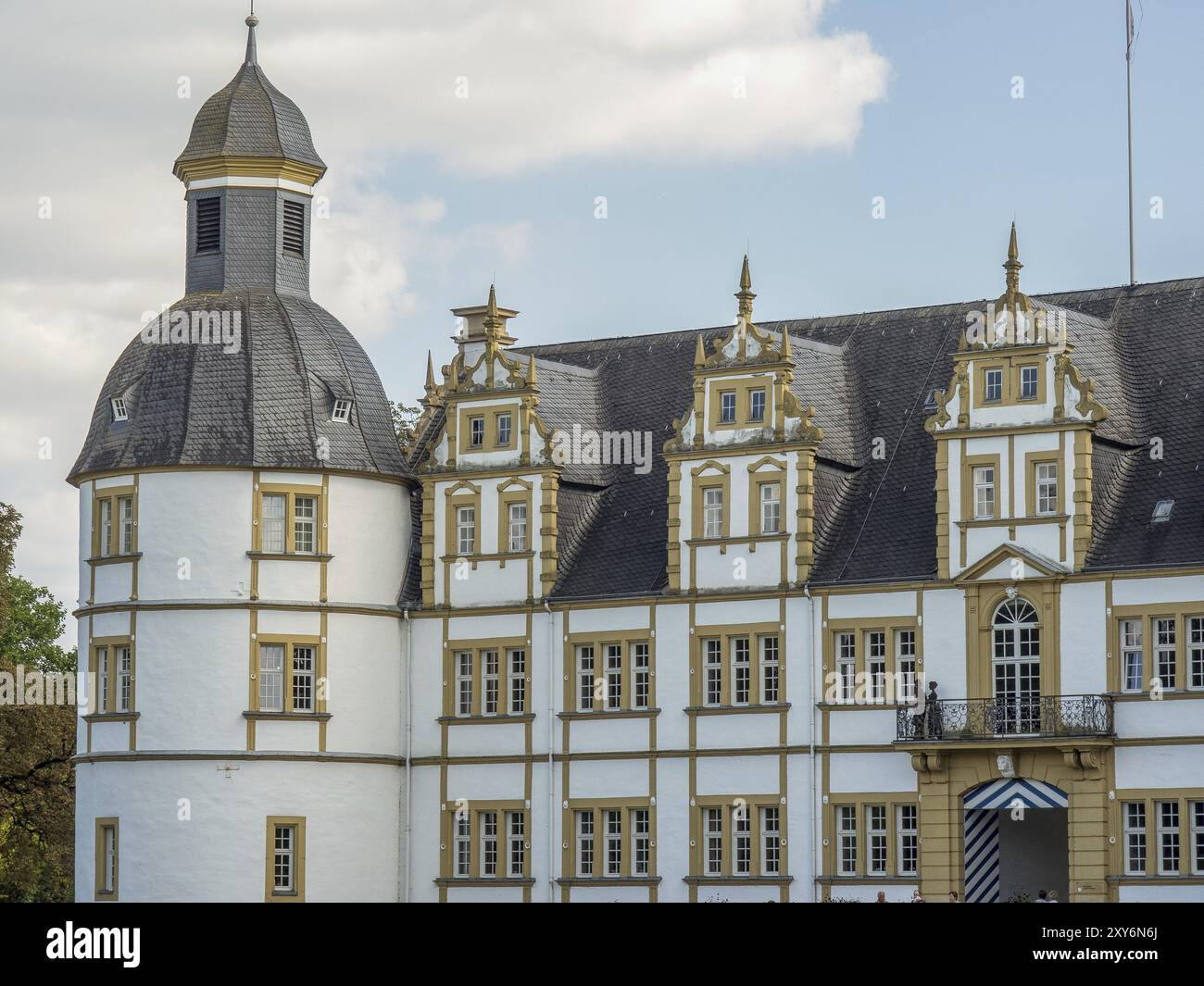 Historic castle with a yellow and white facade and a striking tower ...