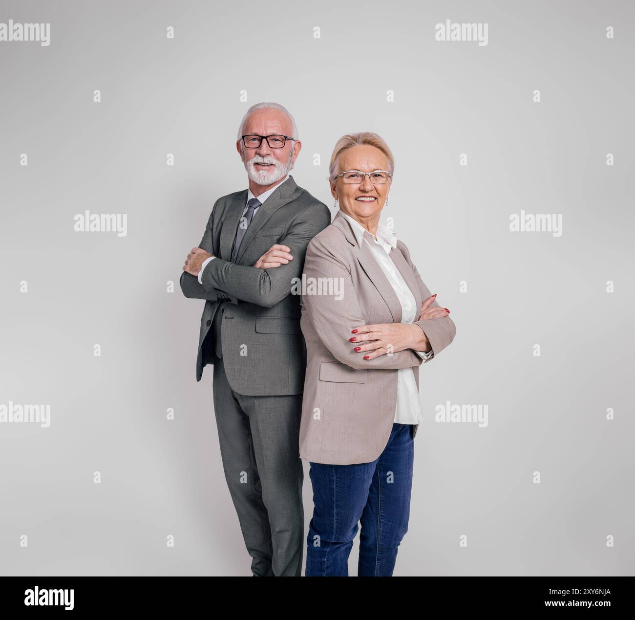 Confident senior partners with arms crossed smiling and posing back to ...