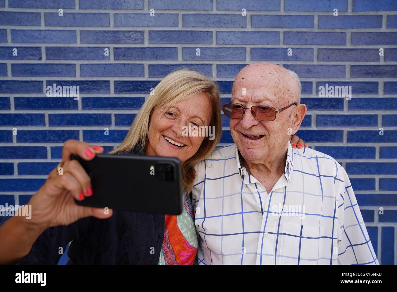Portrait of an older father and his daughter smiling for the mobile ...