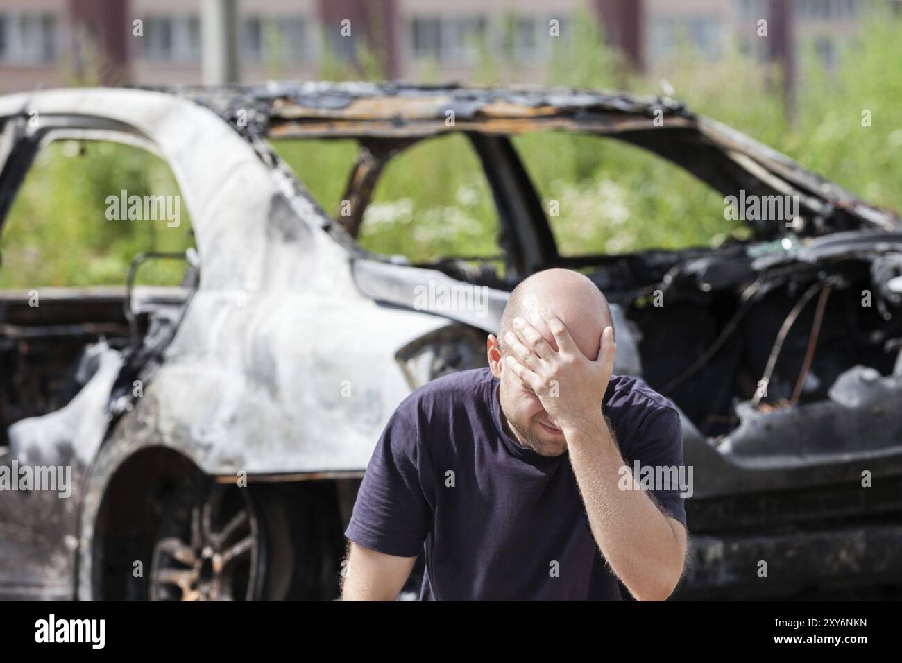Crying upset caucasian man at road wreck accident or arson fire burnt ...
