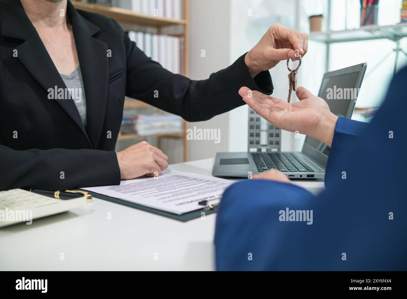 Real estate agent handing over house keys to customer after agreeing to ...