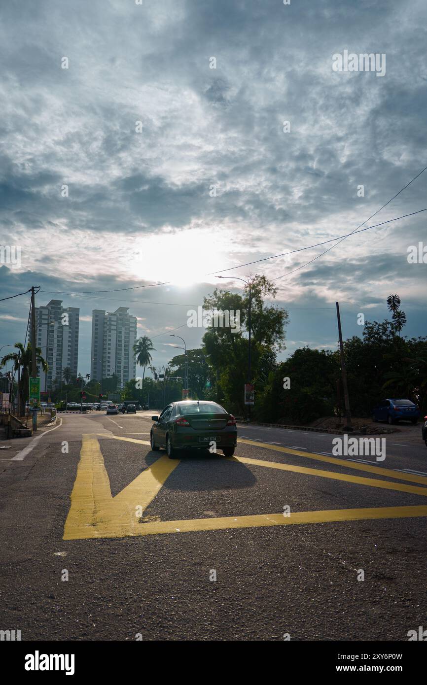 car driving into distance sun buildings road yellow box Stock Photo - Alamy