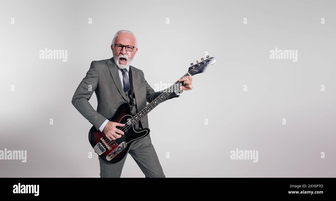 Excited senior rock musician in suit singing with mouth open and ...
