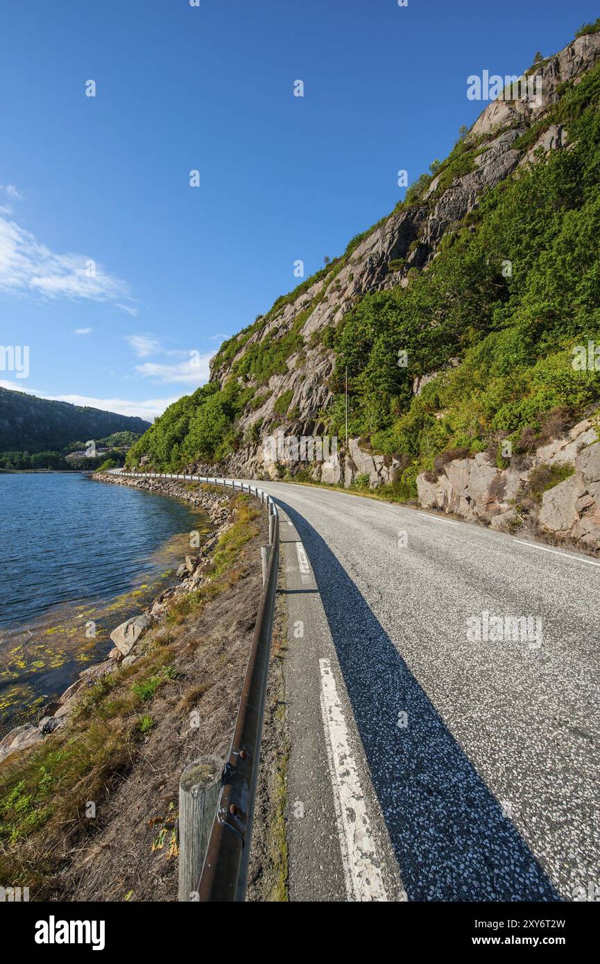 Narrow, winding road by a fjord and steep cliffs above Stock Photo - Alamy