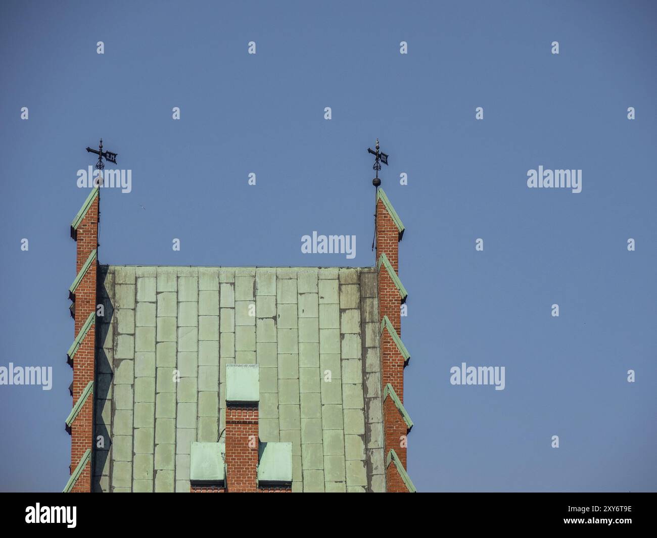 Top of a church tower with green copper panelling and crosses in front ...