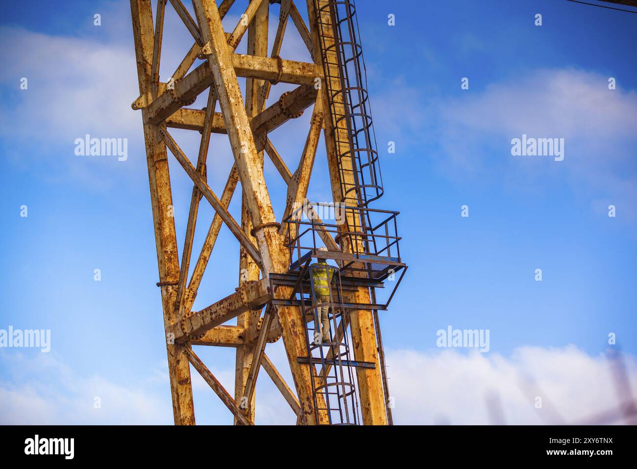 Worker climbing on a crane Stock Photo - Alamy