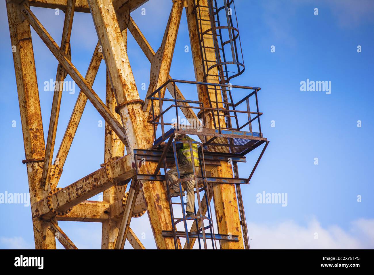 Worker climbing on a crane Stock Photo - Alamy