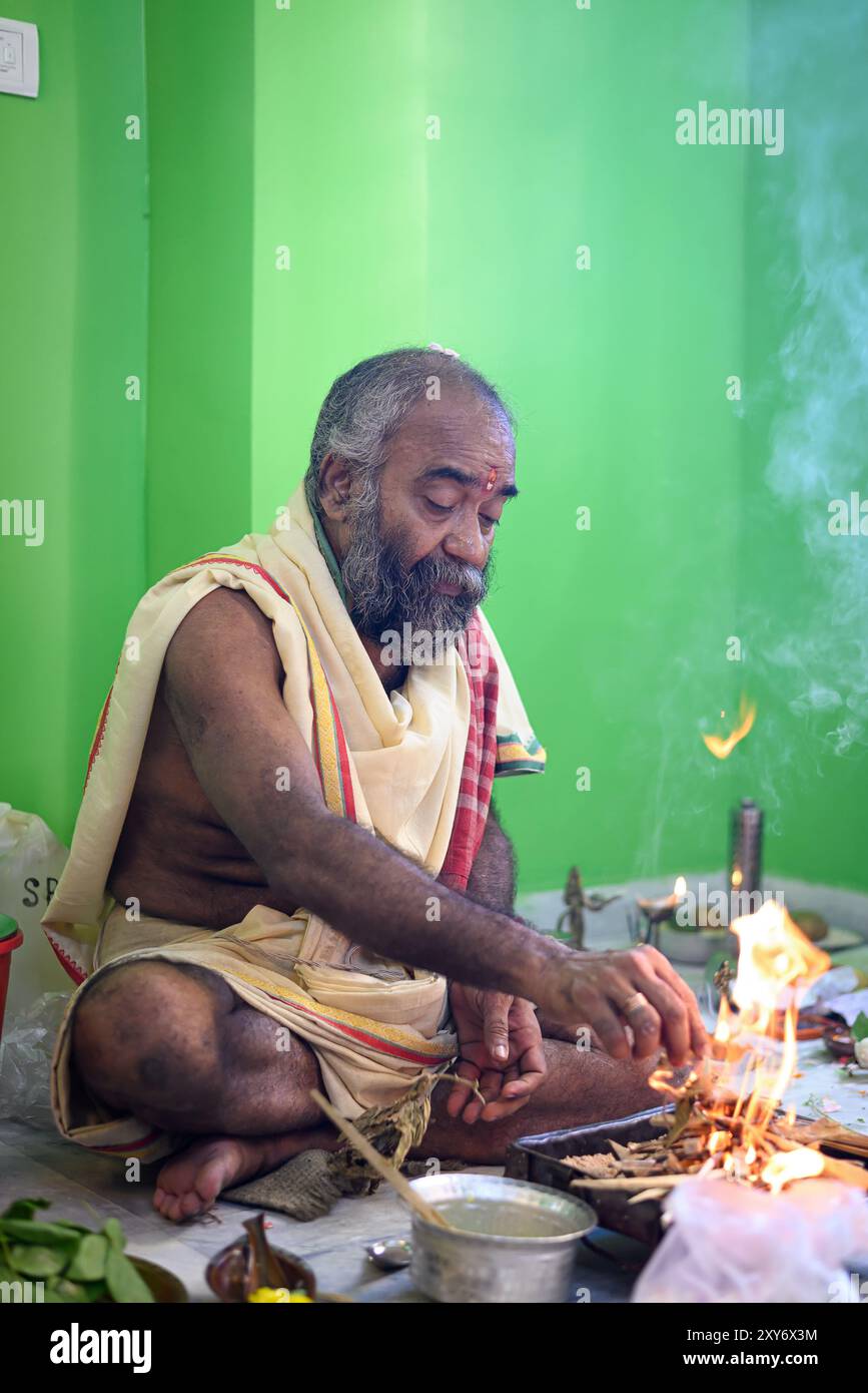 Brahmin performs the Yajna during puja, a traditional Hindu fire ritual ...