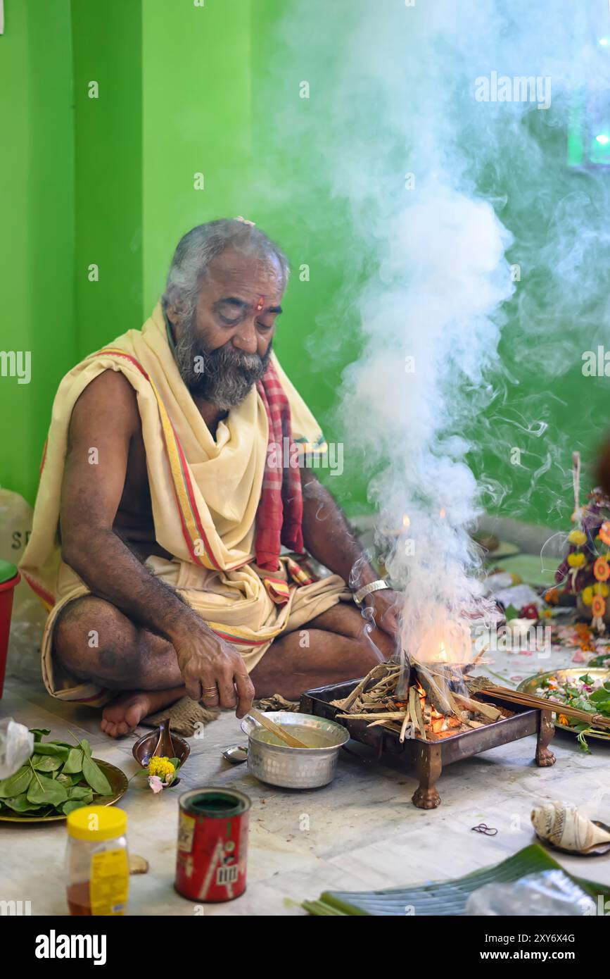 Brahmin performs the Yajna during puja, a traditional Hindu fire ritual ...
