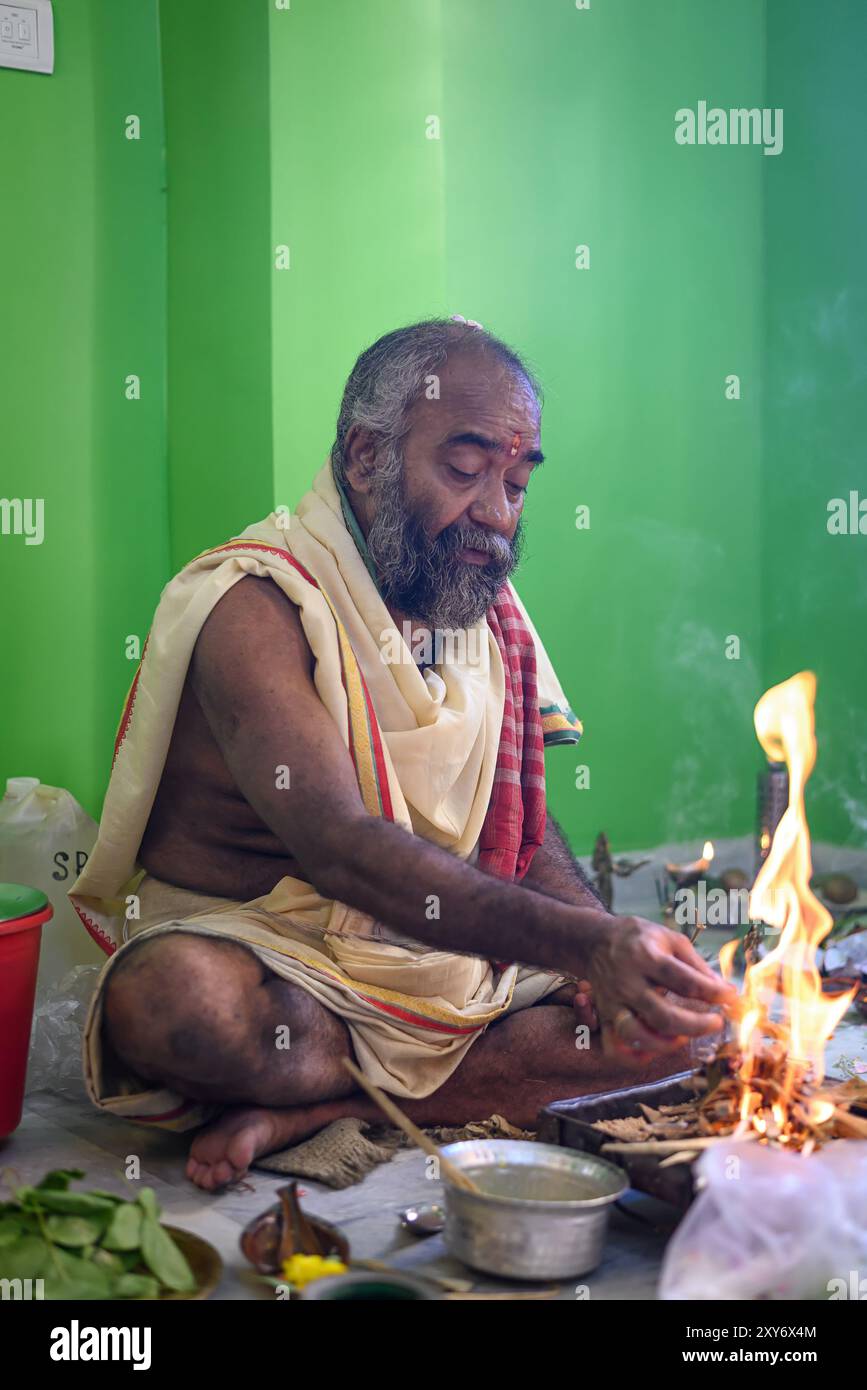 Brahmin performs the Yajna during puja, a traditional Hindu fire ritual ...