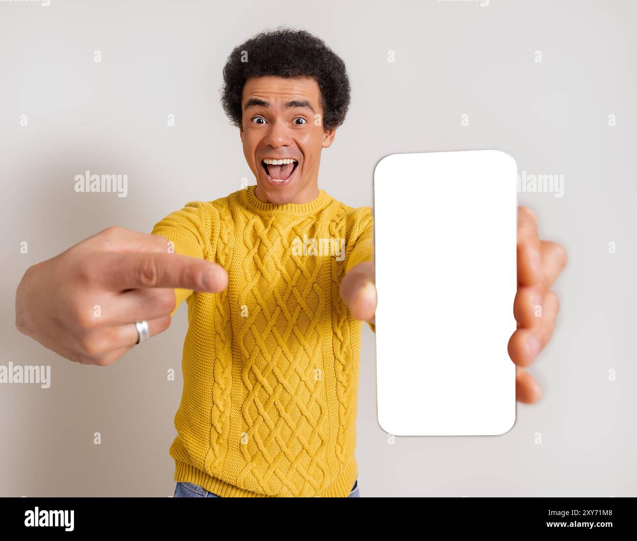 Portrait of excited salesman shouting and pointing at smart phone's ...
