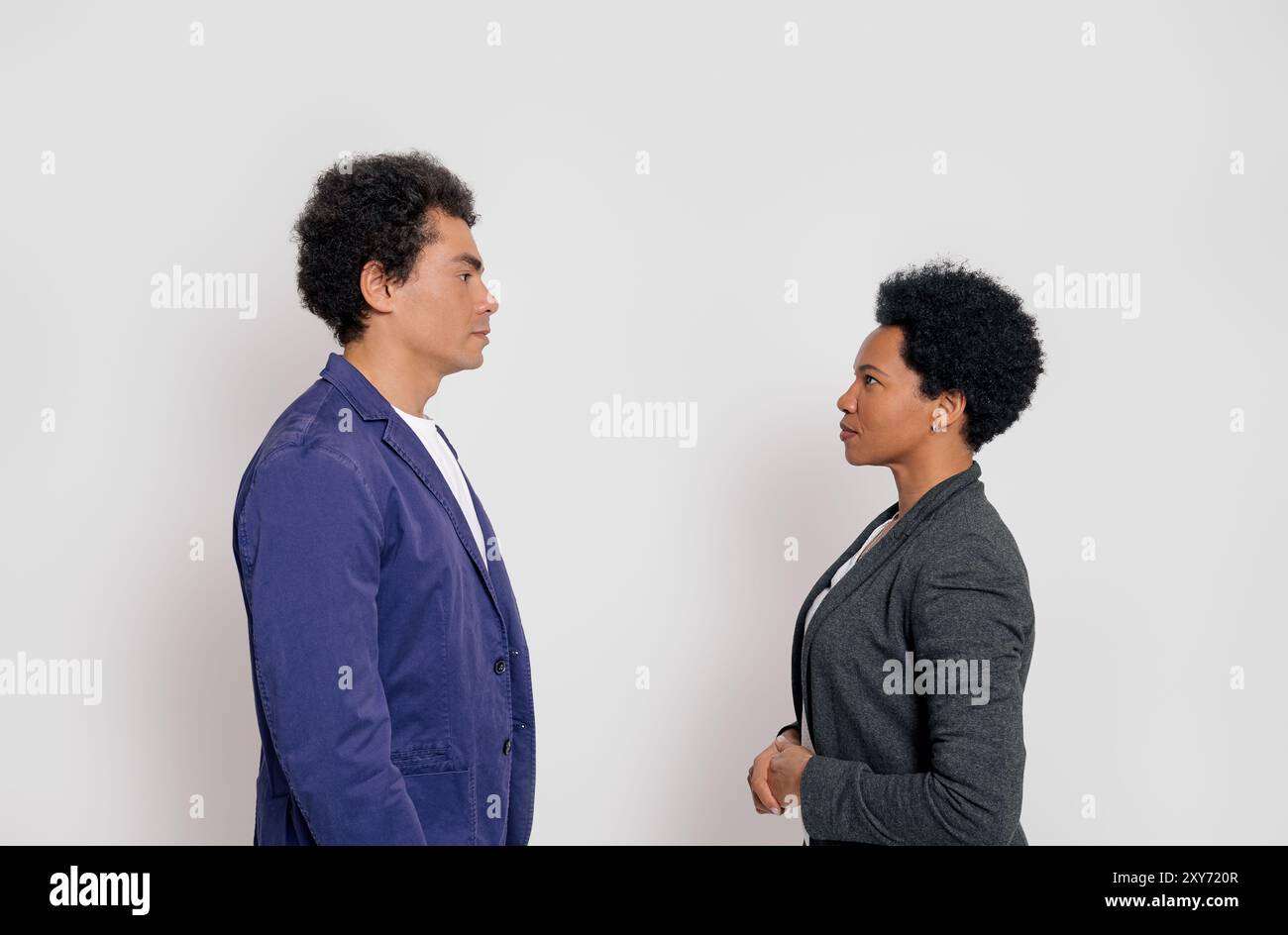 Side view of serious young business coworkers facing each other while ...