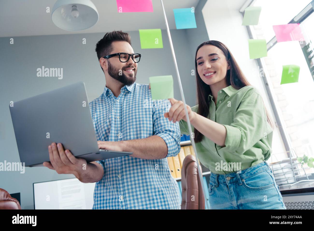 Photo of two people worker use netbook working on project point stickers in workplace Stock ...