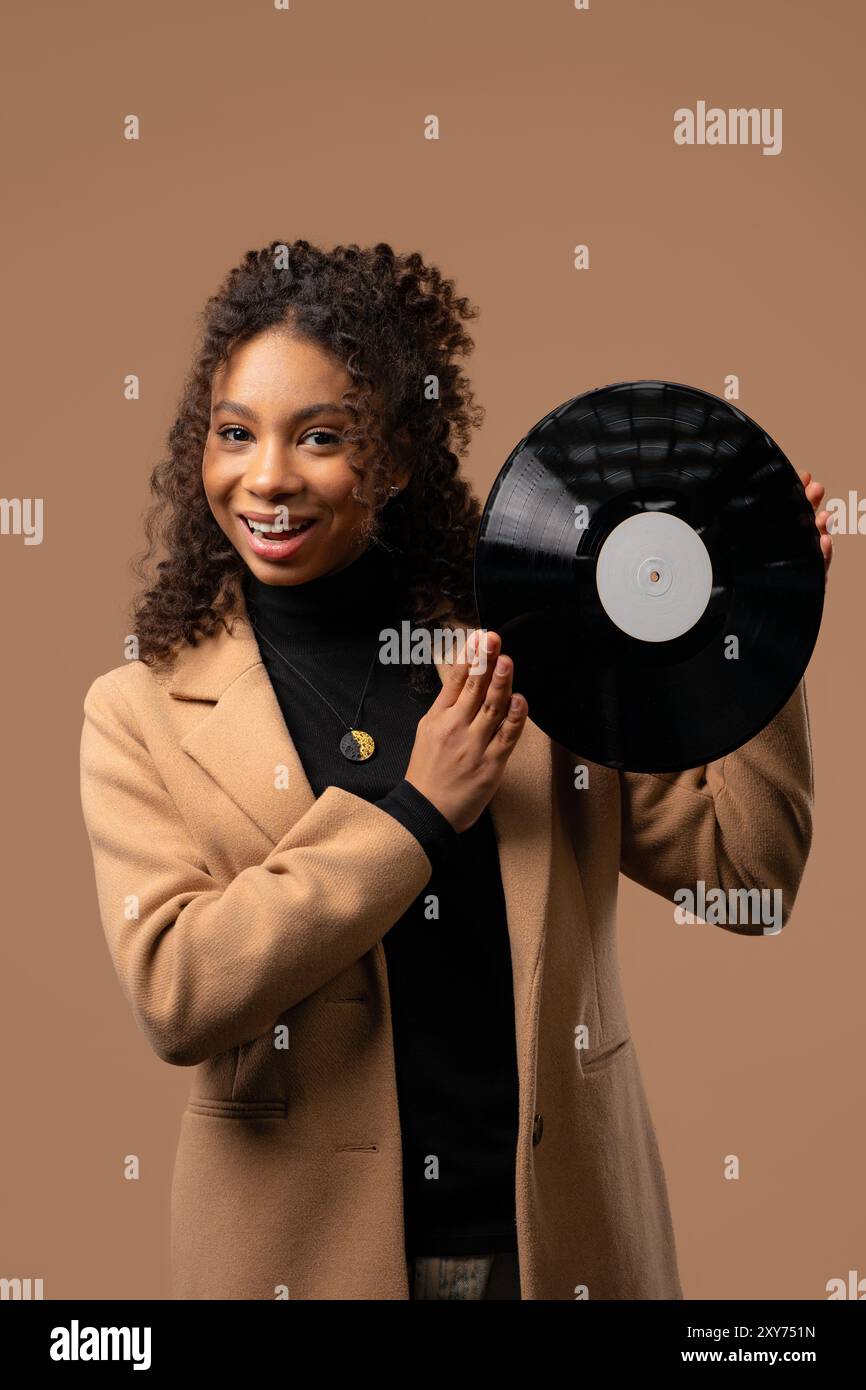 African teenager girl dances with vinyl record disc.Hobby,music lover ...