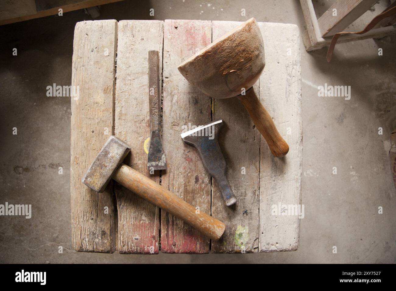 A tool bench with hammers, sticks, iron and chisel with the view from ...