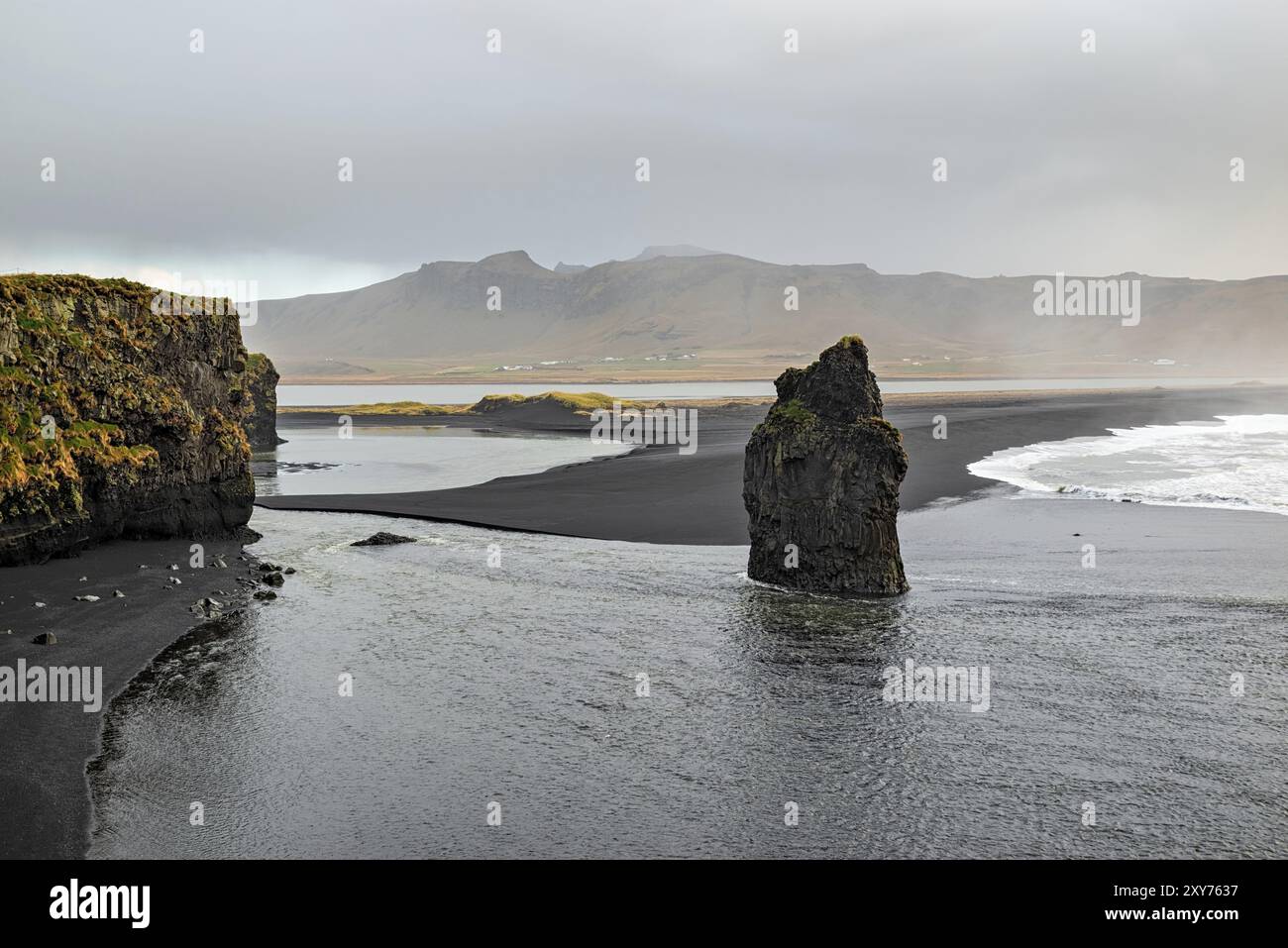 Rock formation on a black volcanic beach at Dyrholaey at sunset ...