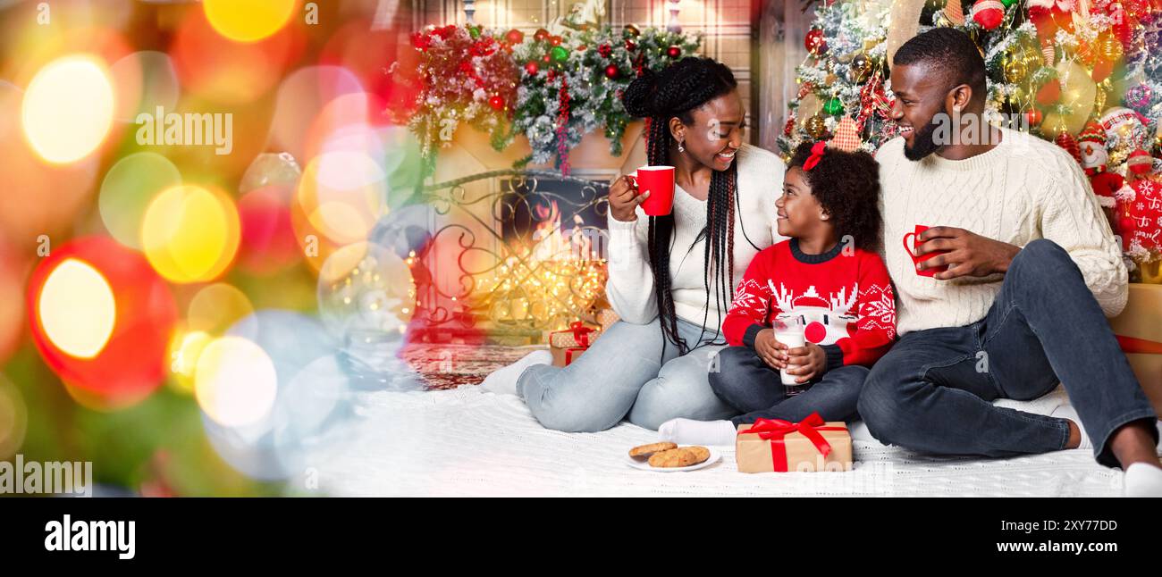 Joyful afro family drinking milk and eating cookies, celebrating ...