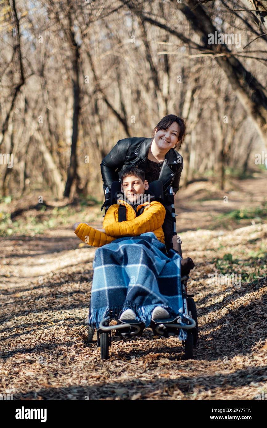 Mother and child with special needs enjoying nature walk in forest ...