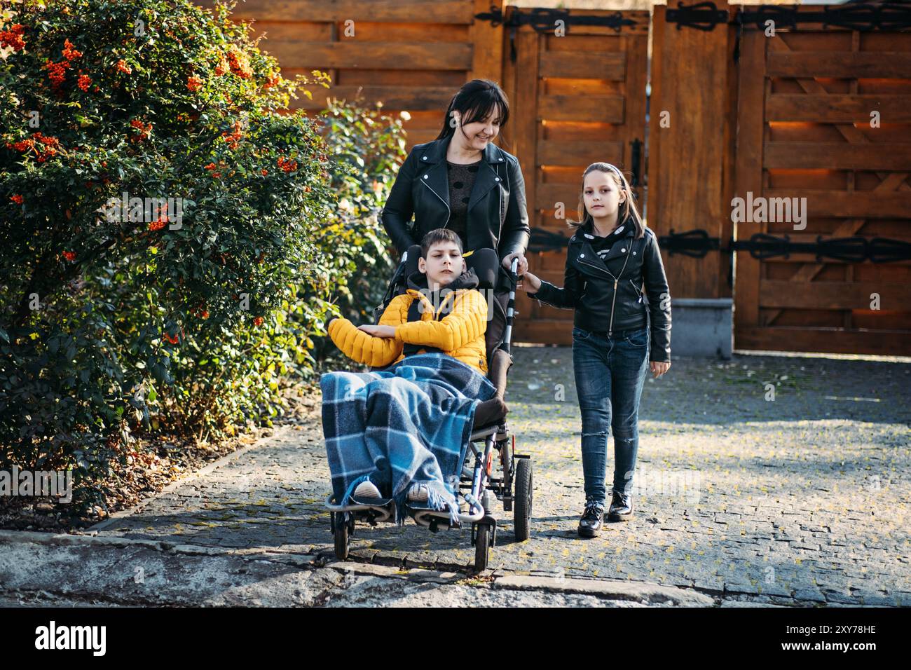 Mother and sibling providing emotional support to child in wheelchair ...