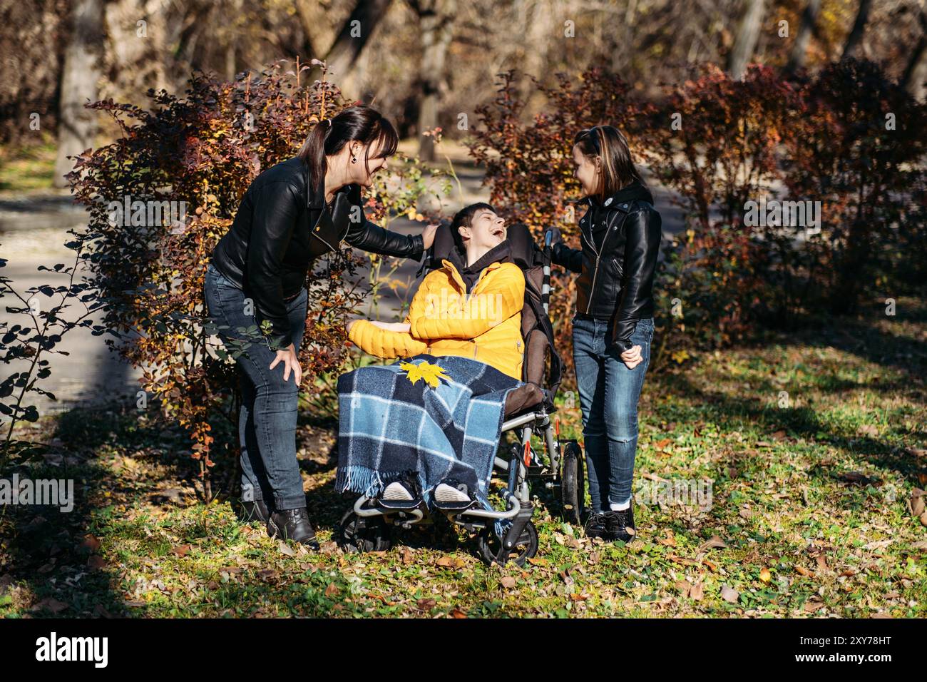 Mother and sibling providing emotional support to child in wheelchair ...