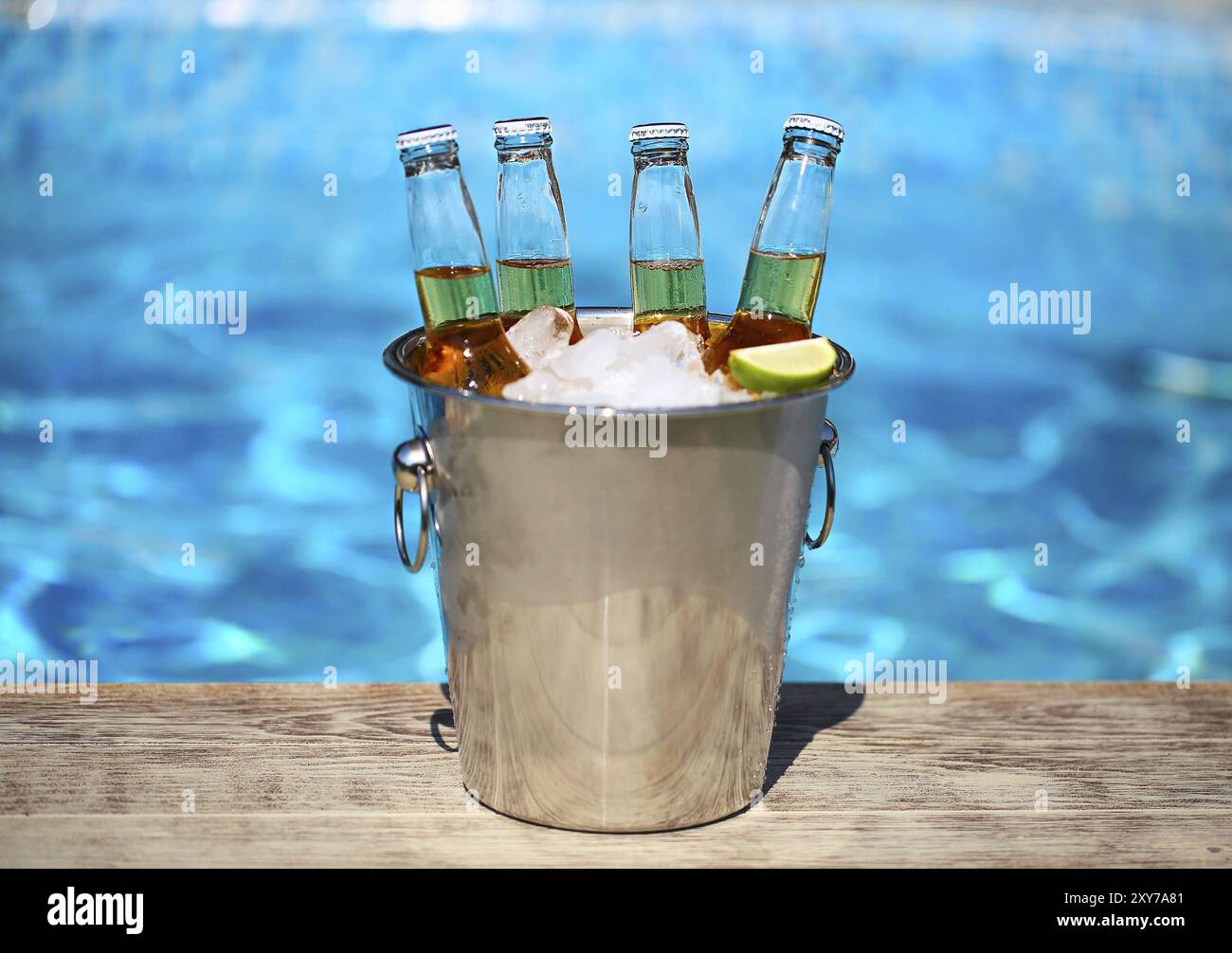 Closeup view of bucket with ice cubes, beer bottles and lime slices by ...