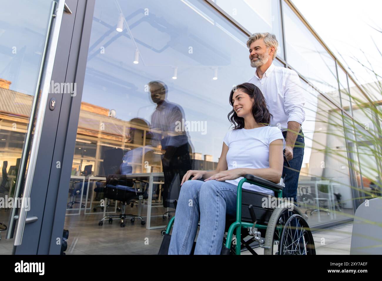 Man carrying a wheelchair of his wife and looking at her with love ...