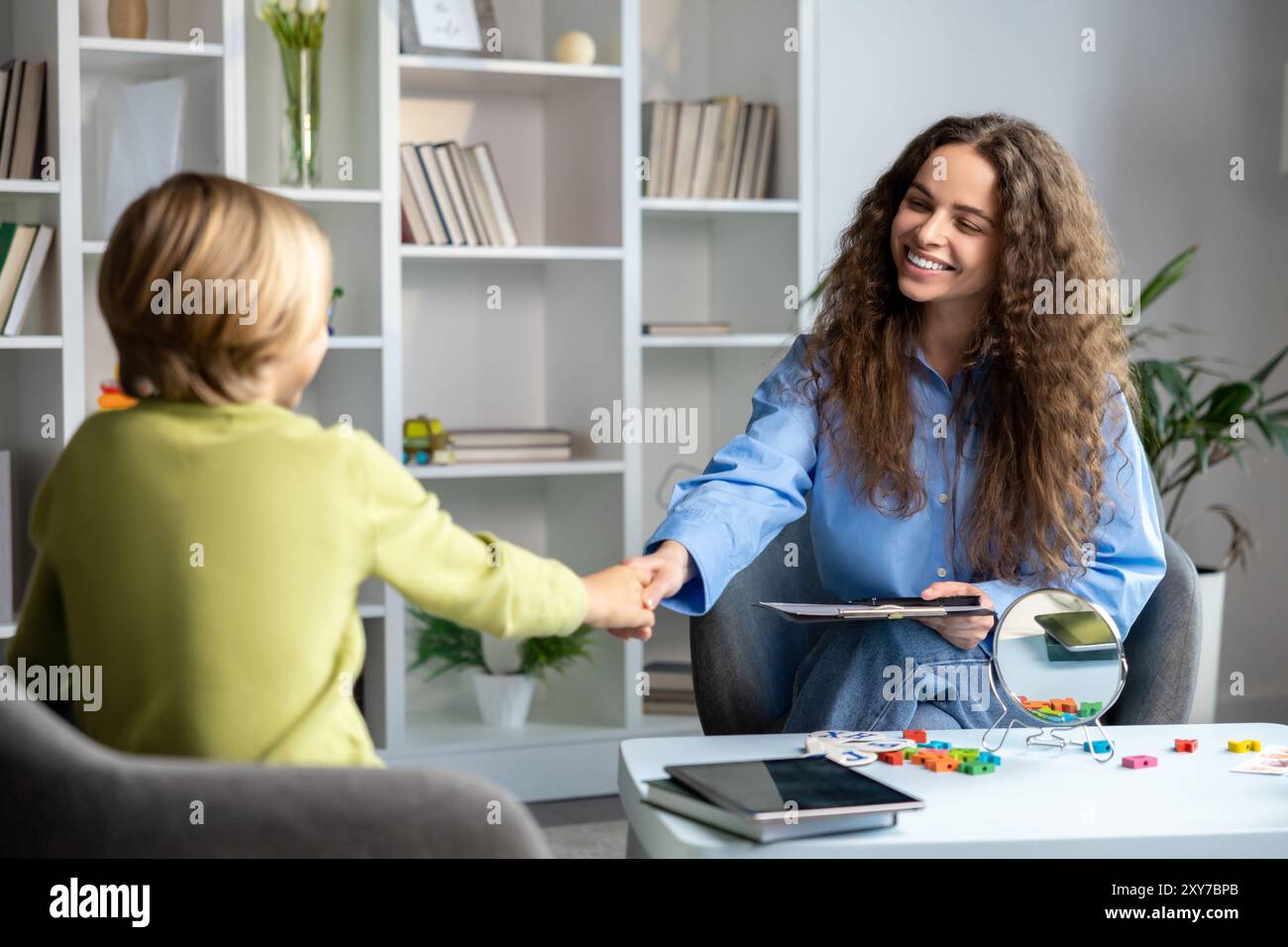 Blonde boy having a speech tutorial with a female speech therapist ...