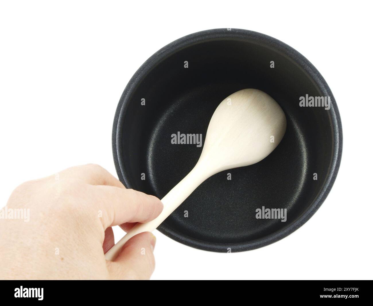 Stainless steel kettle, with wooden spatula and human hand, isolated ...