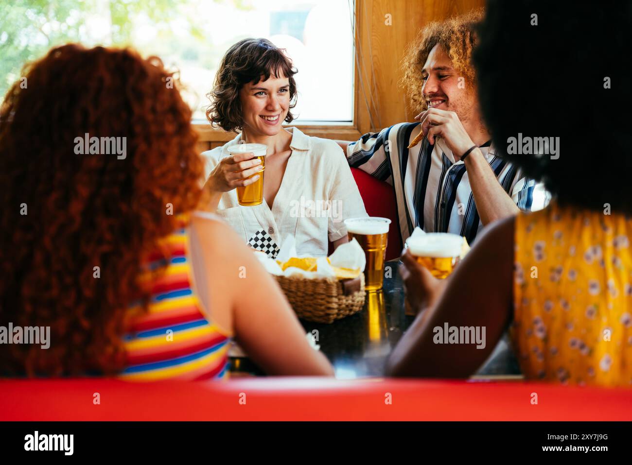 Multiethnic group of friends having meal at 80s vintage diner ...